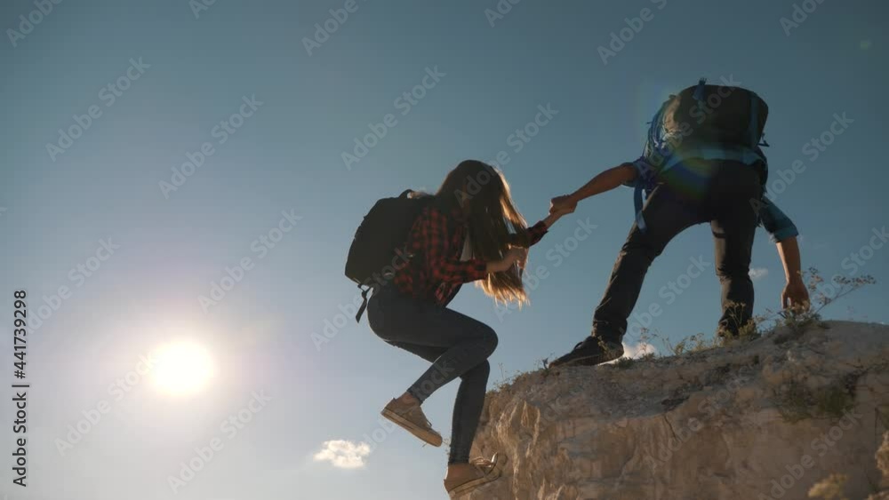 Silhouette of a helping hand between two climbers. Happy family hiking ...