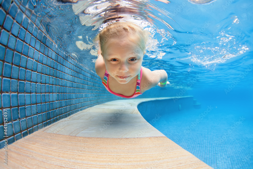 Funny portrait of child learning swimming, dive in blue pool with fun ...