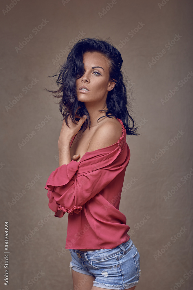 Beautiful sexy woman in skimpy denim shorts with her shirt slipped down ...