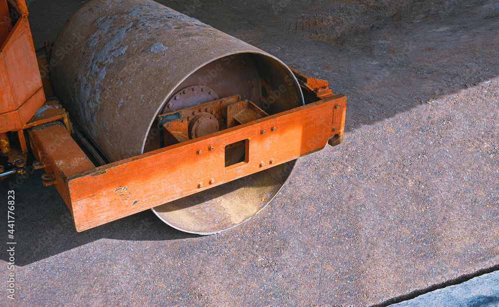 High angle and side view of the old steel wheel roller compacting soil ...