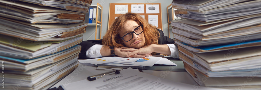 Sad busy clerk looking at too much paperwork. Panorama background ...