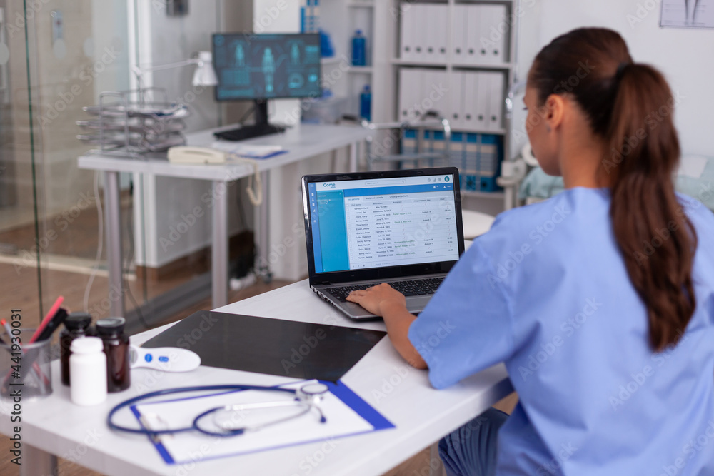 Medical nurse checking patient documentation on laptop in hospital ...