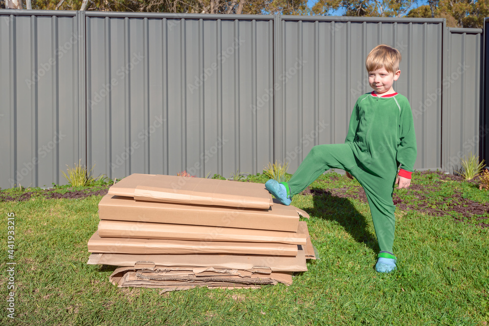 Foto de Little boy standing next to a pile of crushed cartons ready for ...