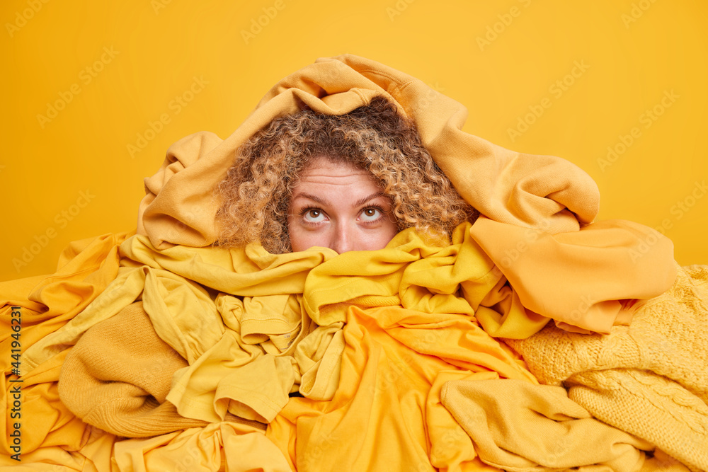 Busy young woman has overflowing closet with outdated clothes focused ...