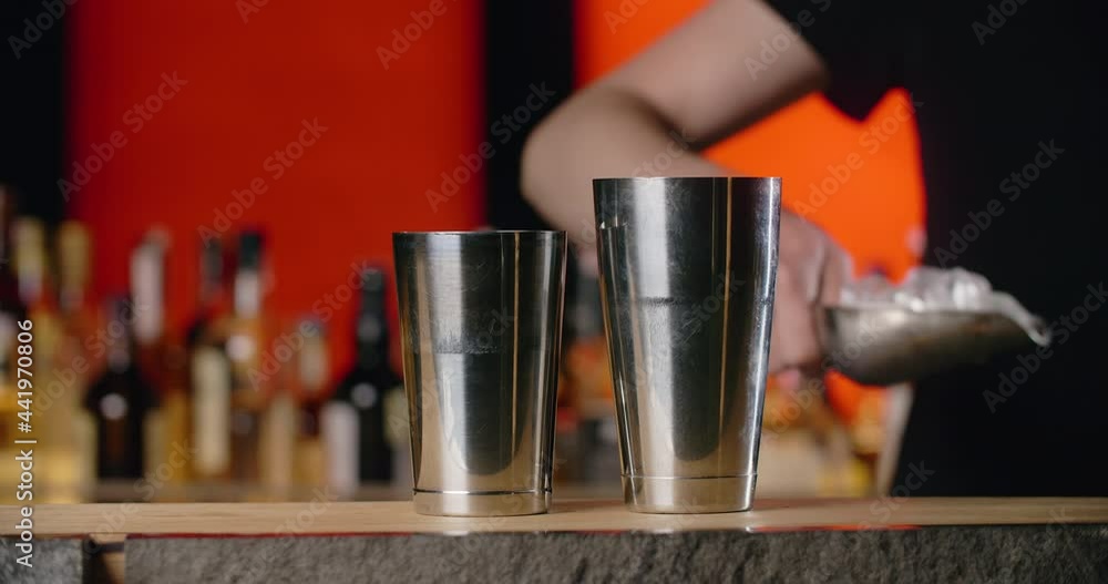 Barman adds ice cubes to the shaker in slow motion, bartender mixes ...