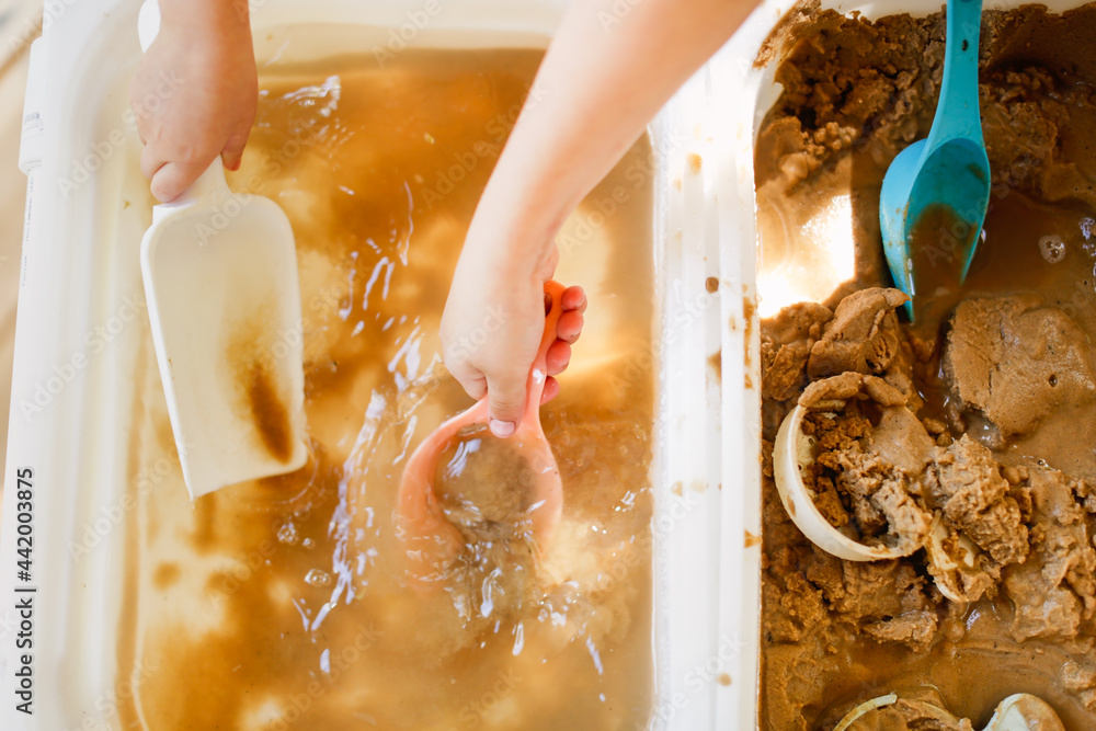 Happy children play with sand and water in sensory baskets on the ...