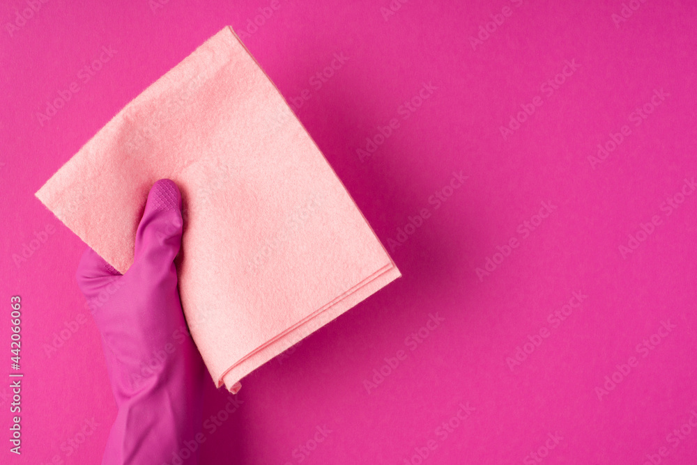 Top view photo of hand in pink glove holding pastel pink napkin on ...
