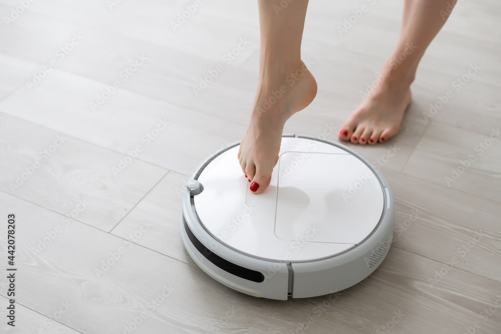 Human leg using smart robotic technology vacuum cleaner cleaning floor ...