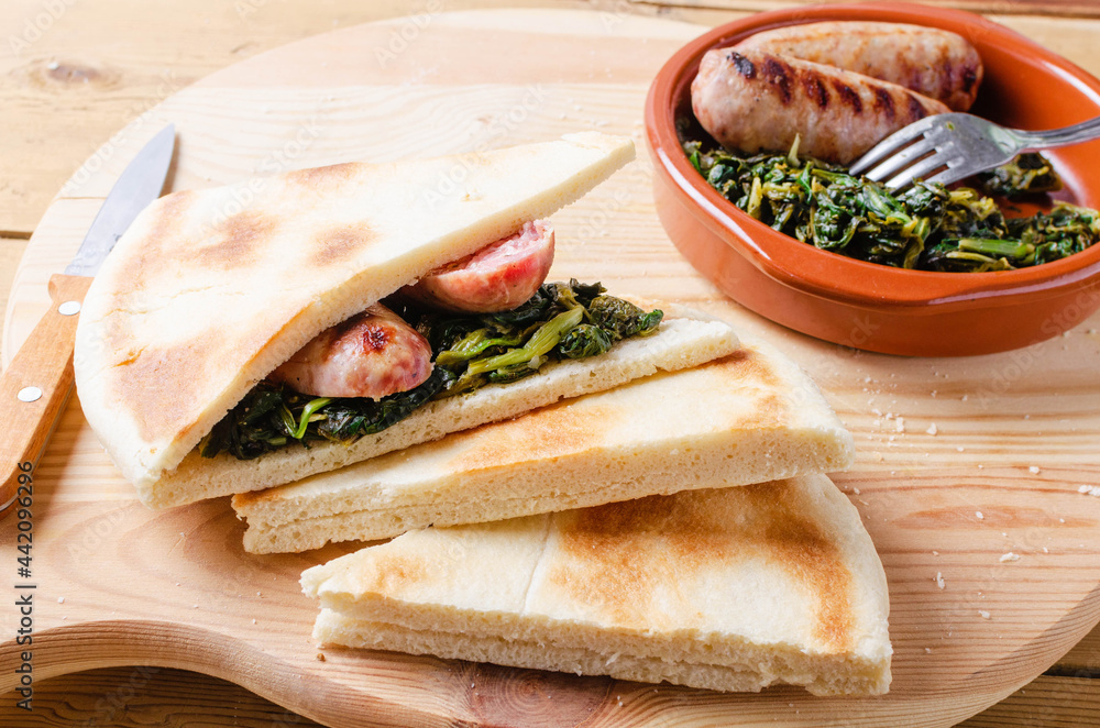 Foto de Torta al testo, flatbread with spinach and grilled sausage ...