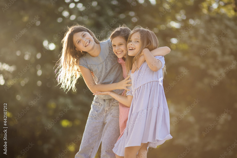 Kids in hug. Three little girls playing in nature together. Stock Photo ...