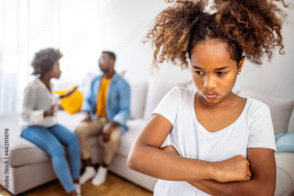Frustrated little girl scared with mom and dad fighting at home, sad ...
