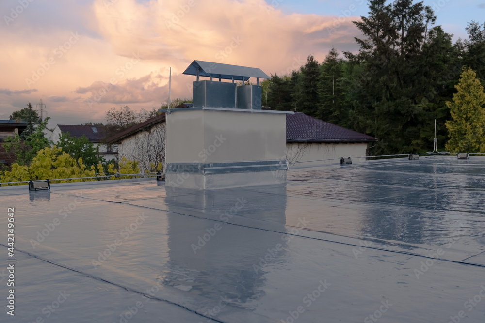 Flat roof covered with bitumen membrane and silver lacquer with chimney ...
