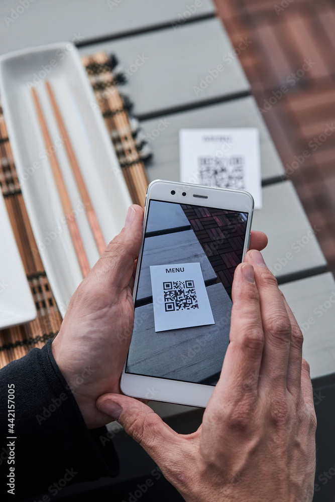 Crop man scanning QR code of restaurant menu Stock Photo | Adobe Stock