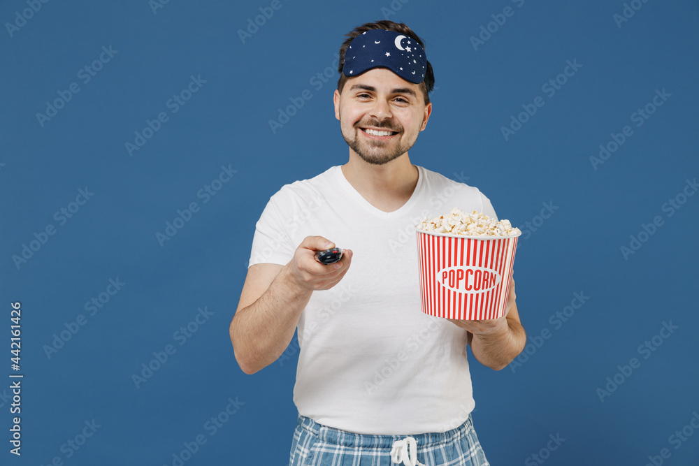 Young man in pajamas jam sleep mask rest home hold takeaway popcorn ...