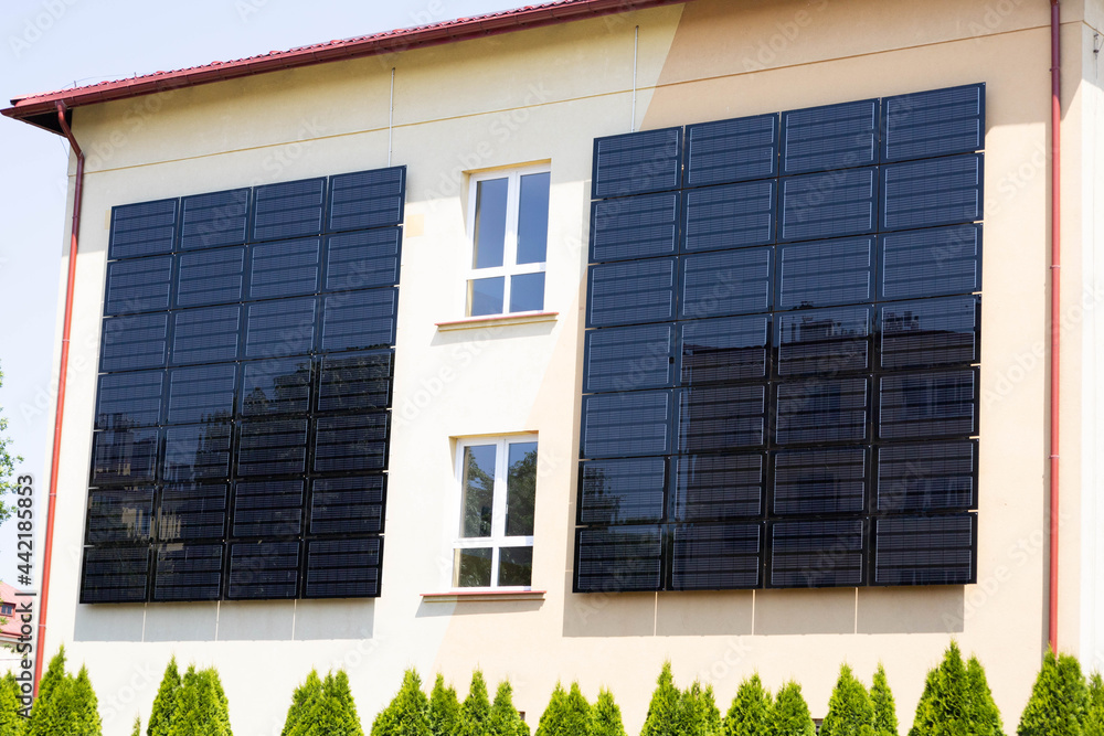 Solar panels installed on the outer wall of building. Wall of the ...