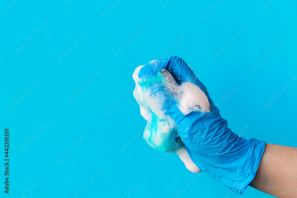 Hand in blue nitrile glove clenched sponge with foam. Stock Photo ...