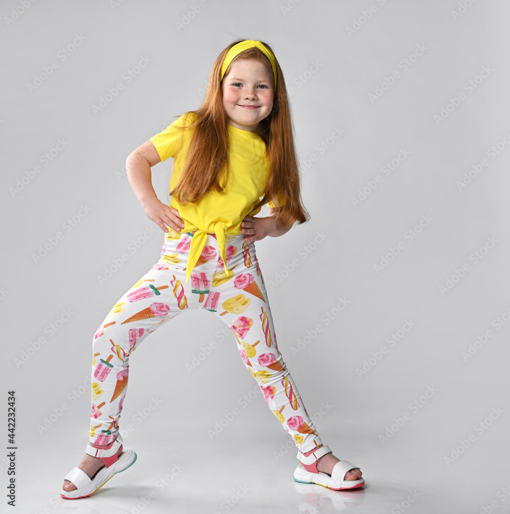 Studio shot of a cheerful little red-haired girl in a summer ...