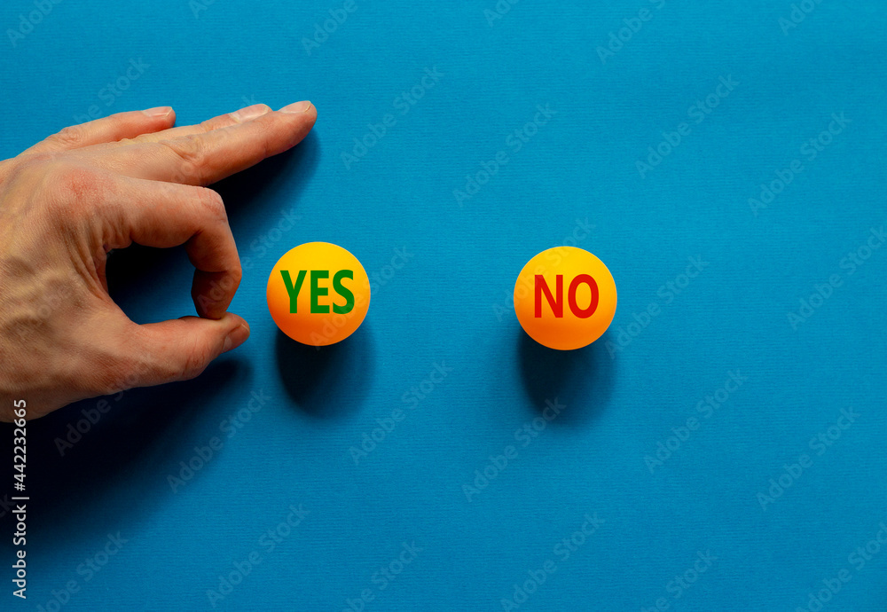 Yes or no symbol. Male hand is about to flick the ball. Orange table ...