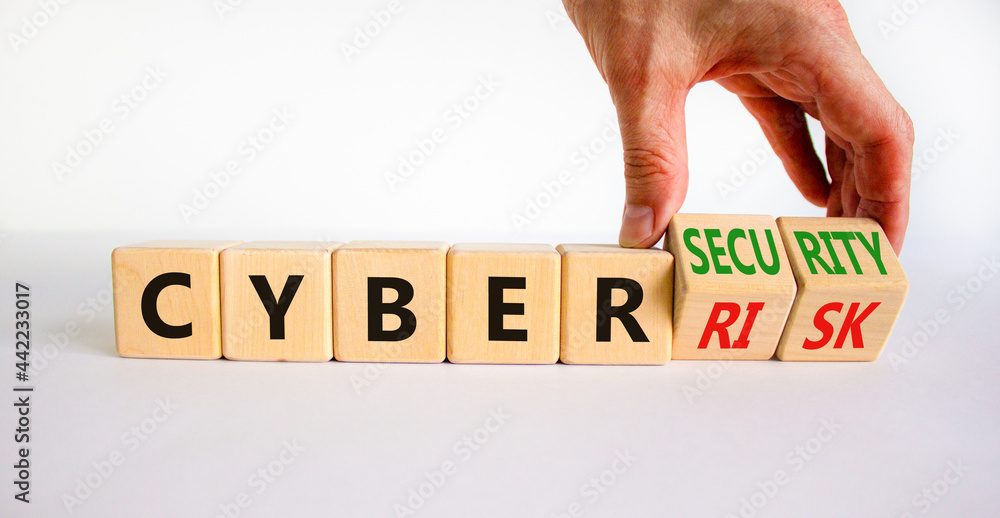 Cyber-security vs cyber-risk symbol. Businessman turns wooden cubes ...