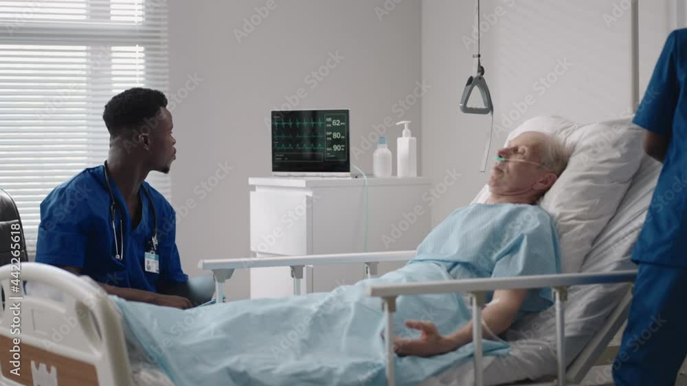 African young doctor team consulting covid-19 infected patient in bed ...