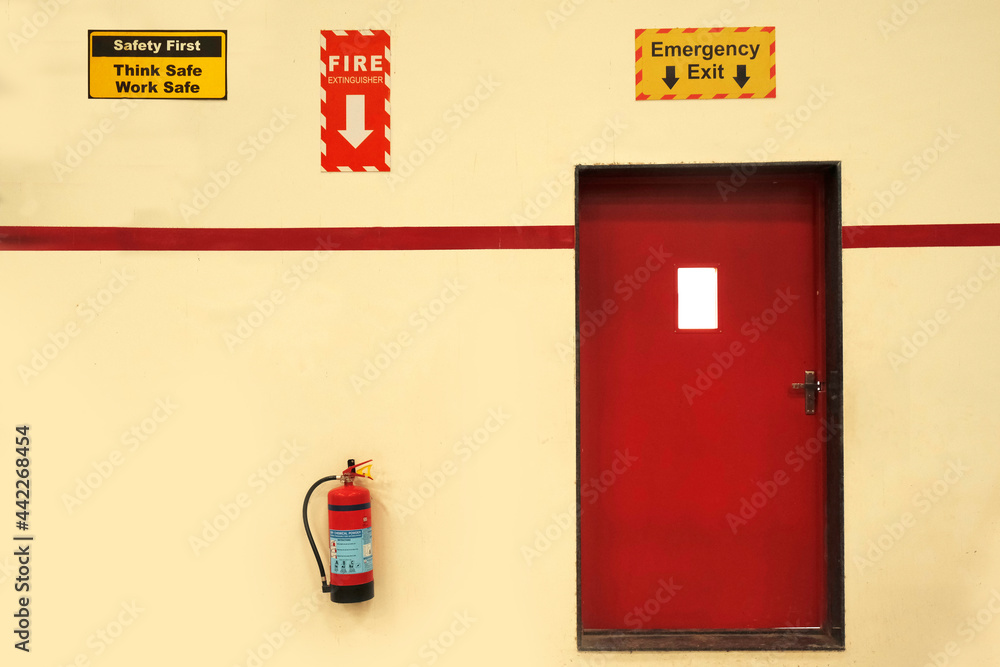 Emergency Exit door with Fire extinguishers in the warehouse. Fire ...
