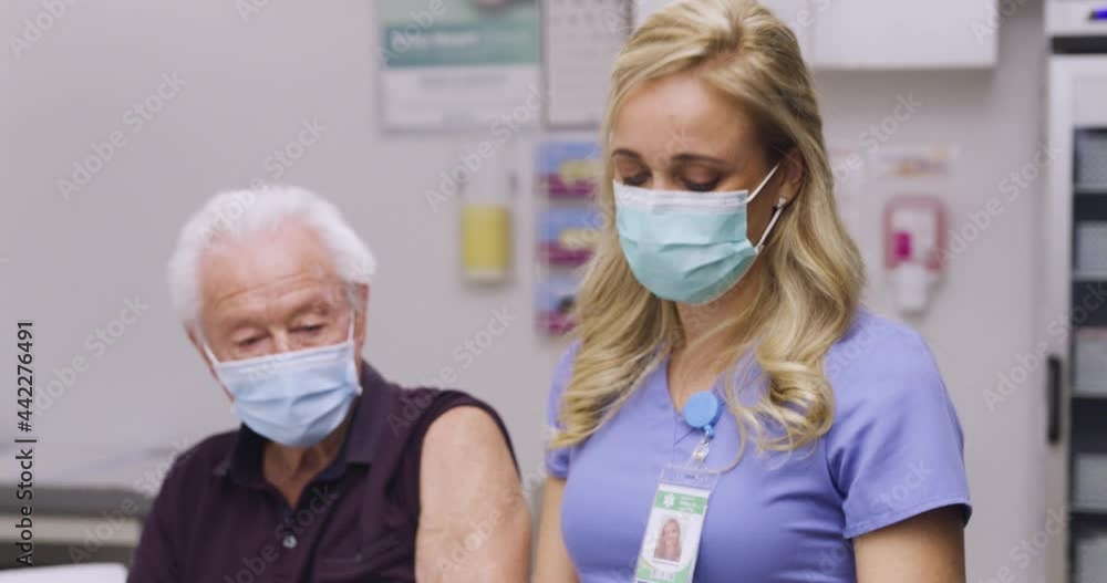 A Mid Shot Of A Female American Medical Nurse Administering A Covid-19 ...