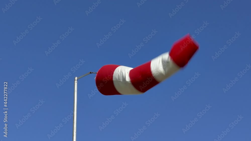 Windsock flutters in a strong wind showing wind direction and speed ...