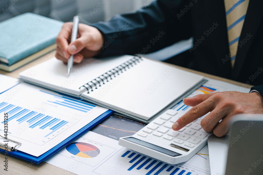 Businessman presses a calculator to calculate. and holding a pen and ...