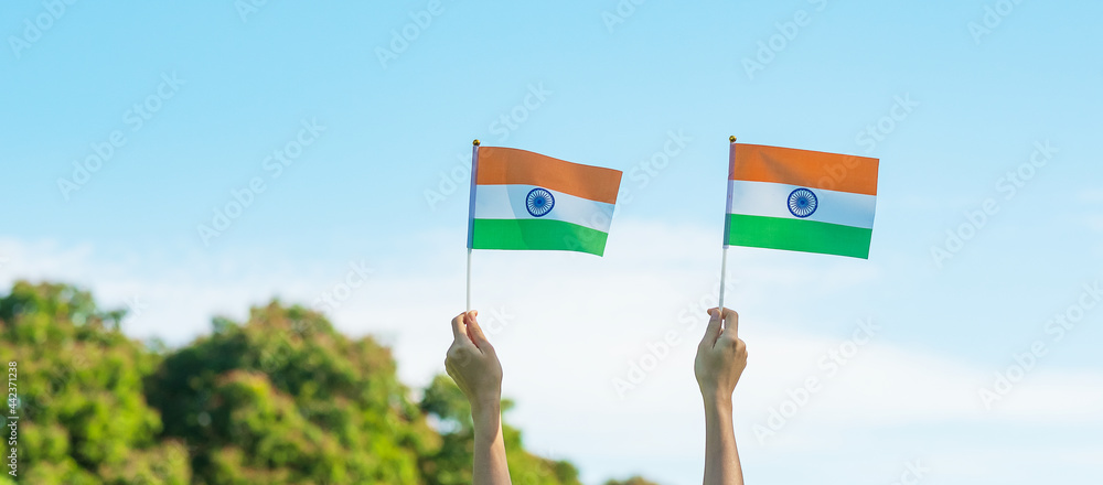 hand holding India flag on blue sky background. Holiday of India ...