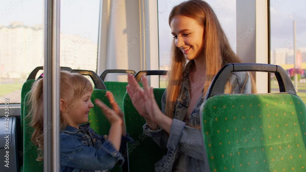 Young happy family rides in public transport tram, mother with blonde ...
