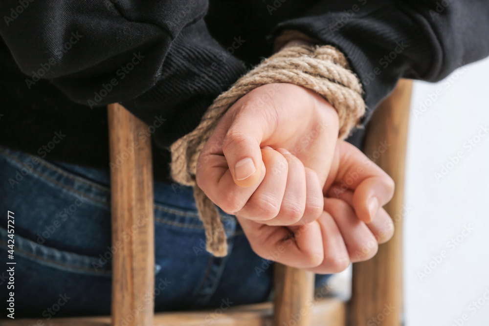 Female hostage with tied hands sitting on chair in room, closeup Stock Photo | Adobe Stock