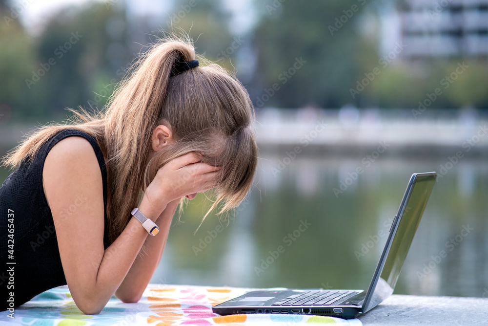 Tired female office employee working behind laptop computer lying down ...