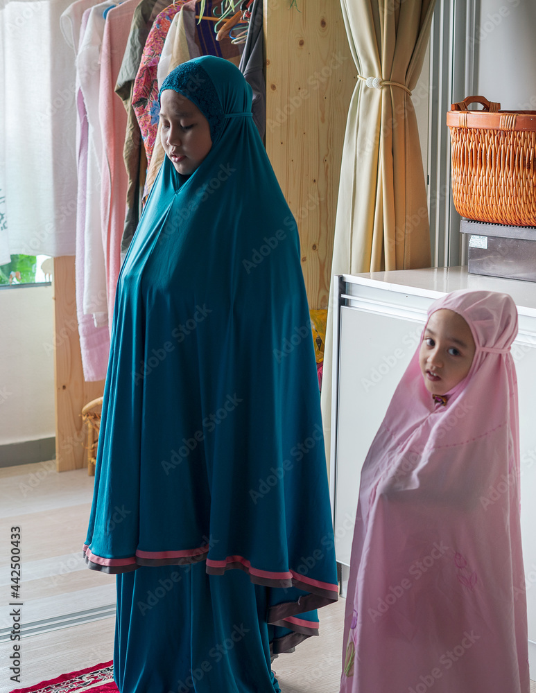 Muslim children praying at home. Learning to pray for the little girl ...