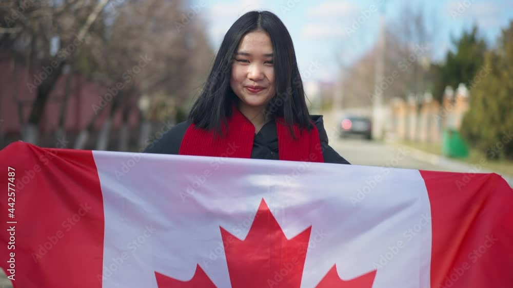 Confident smiling Asian young woman looking at camera smiling holding ...