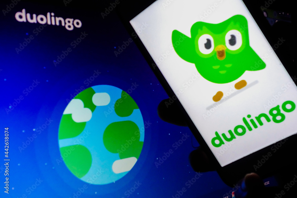 smartphone with Duolingo language app logo on screen. Blurred ...