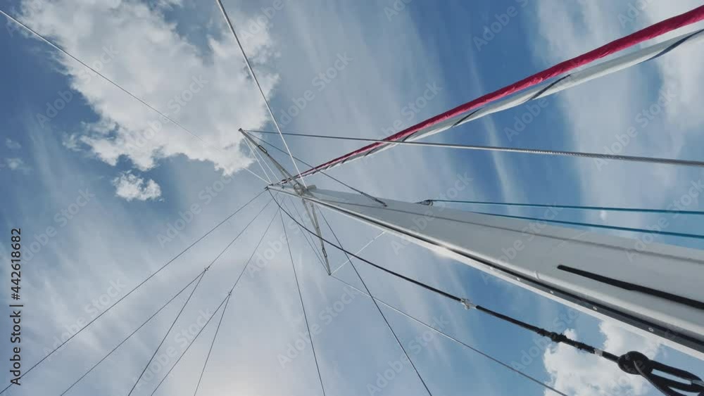 The bottom view on a mast of the sailboat, a sail are curtailed, a ...