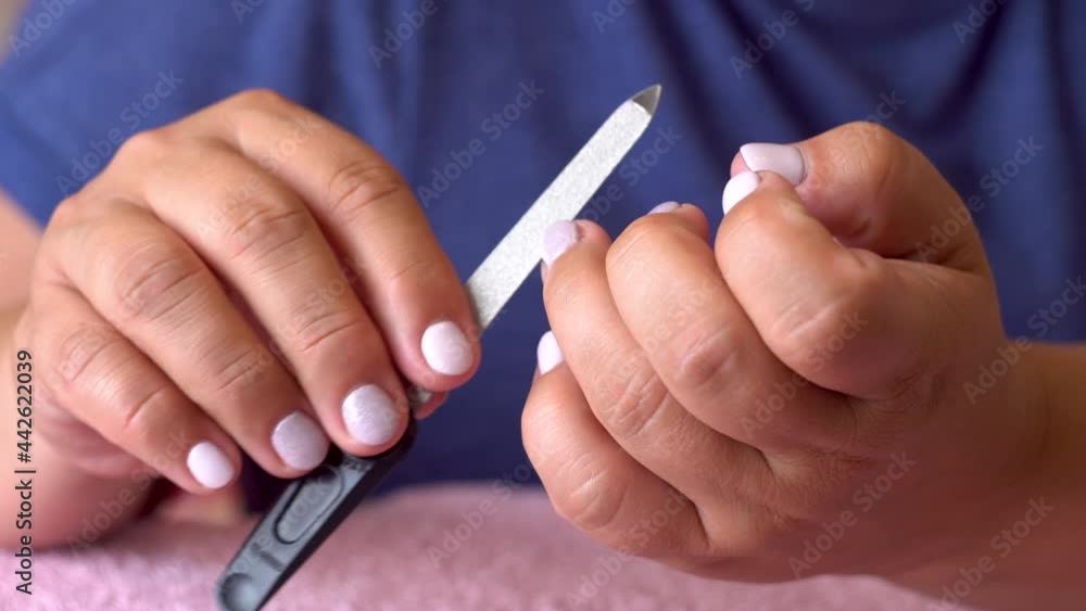 Women's hands. Light nail polish. Manicure. In hand is a nail file ...
