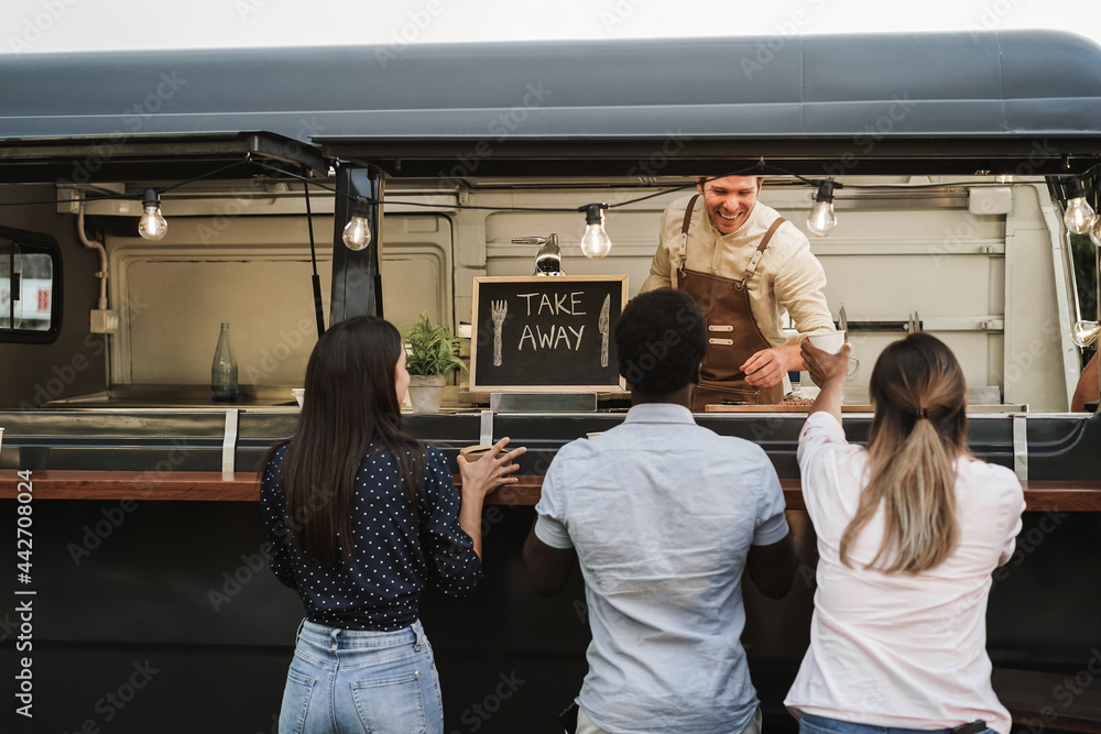 Multiracial people ordering takeaway food at counter in food truck ...