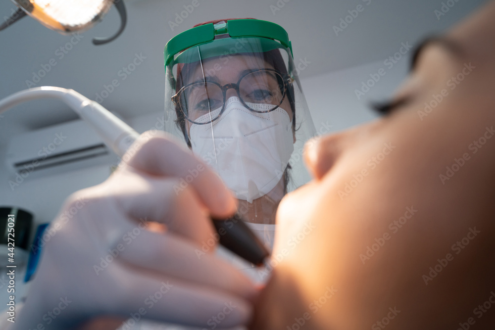 Dentist curing tooth of female patient Stock Photo | Adobe Stock