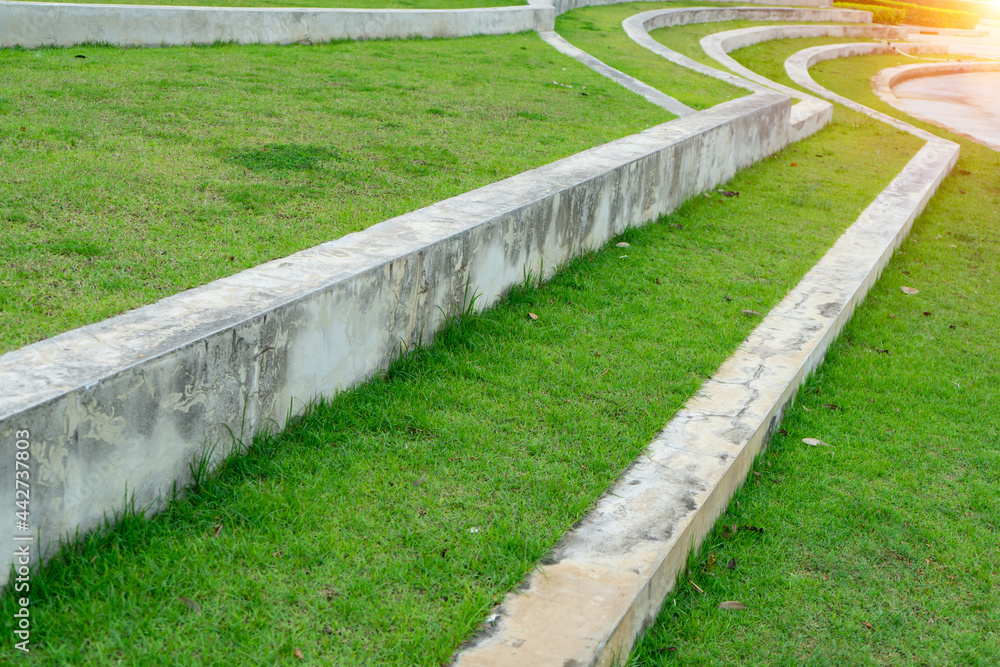 Concrete curb along and curve on the grass lawn that make to the ...