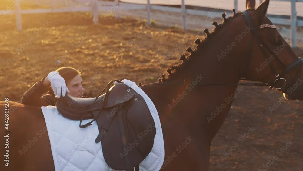 Stockvideo Horsewoman climbing on horseback with the help of its lead ...