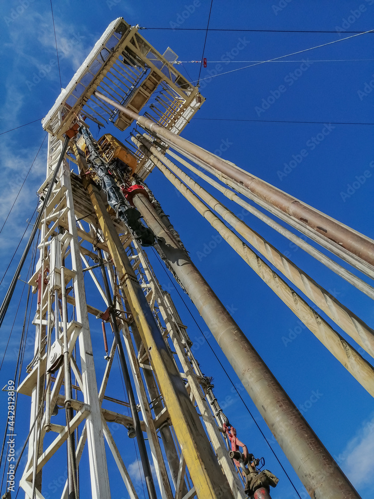 Inside view of the drilling rig from bottom to top. Steel drill pipes ...