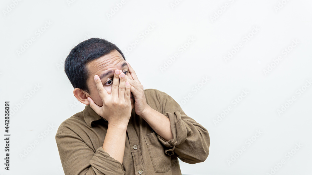 Wow and shocked face expression of young shy Asian Malay man cover face ...