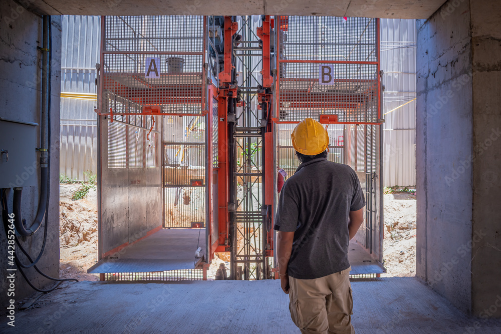 Engineer under inspection and checking elevator under construction in ...