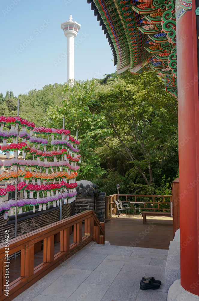 Shoes outside entrance to Buddhist temple. High Busan Tower at ...