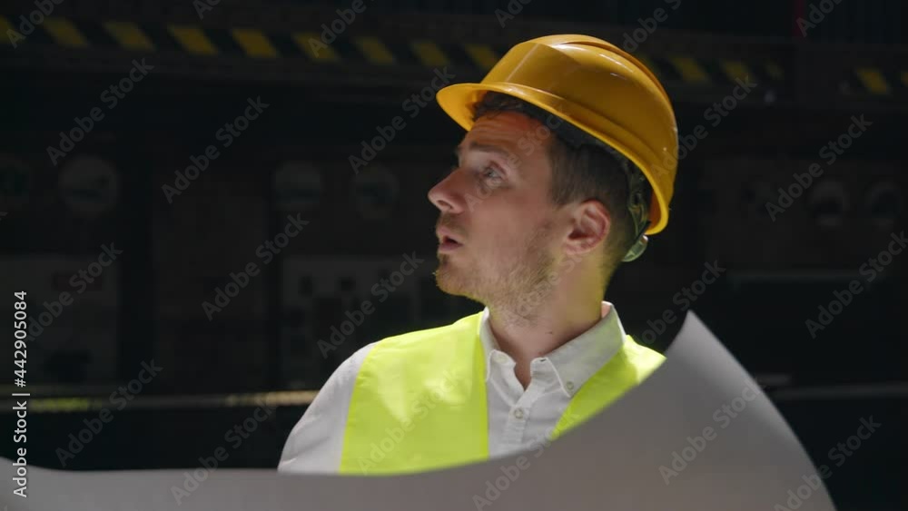 Young man engineer inspection of a row with drawings in his hands. A ...