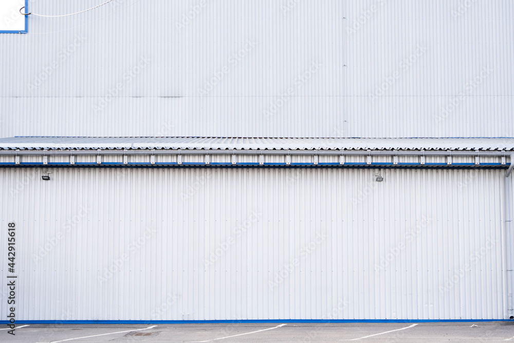 White corrugated iron sheet used as a facade of a warehouse or factory ...