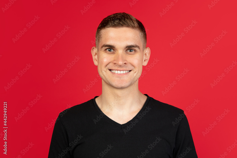 Caucasian man's portrait isolated over red studio background with ...