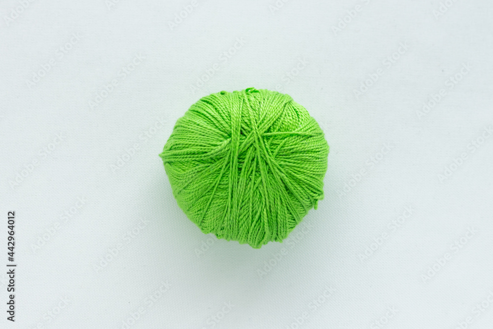 One round ball of green color in the center of the frame on a white ...