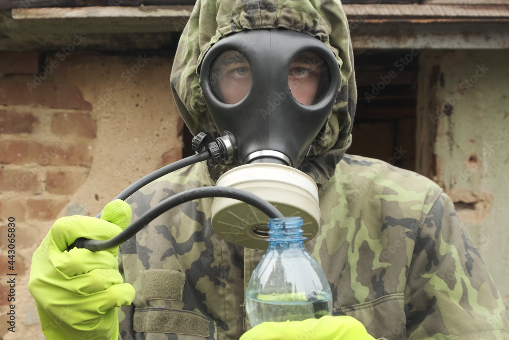 A Man In A Gas Mask drink water from tube pipeline. Apocalypse thirst ...